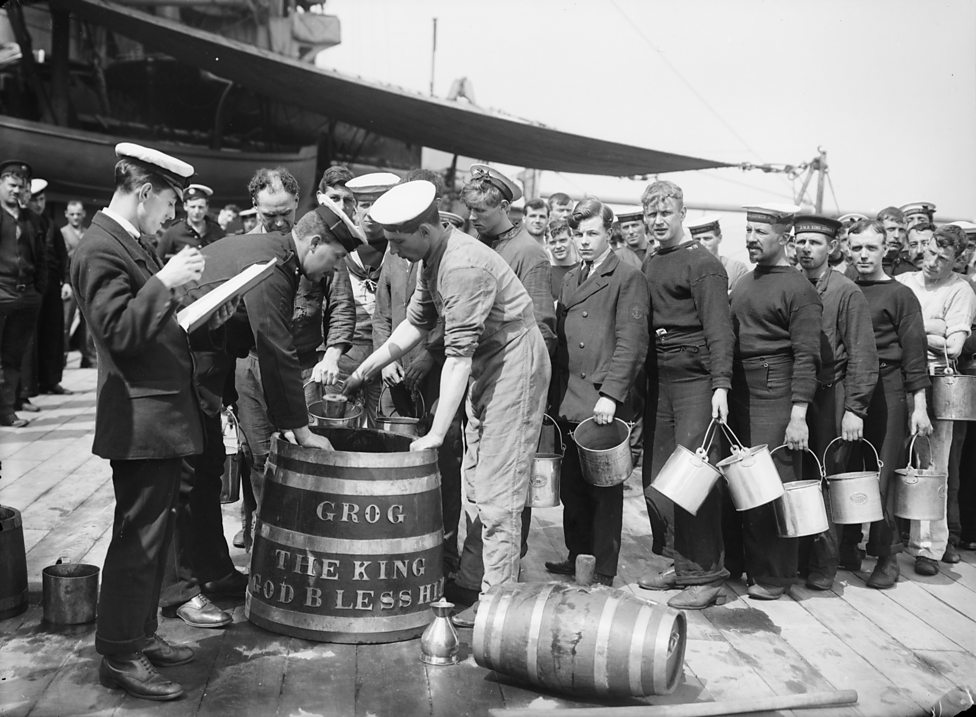 Royal Navy ratings draw a rum issue aboard battleship HMS King George V ...