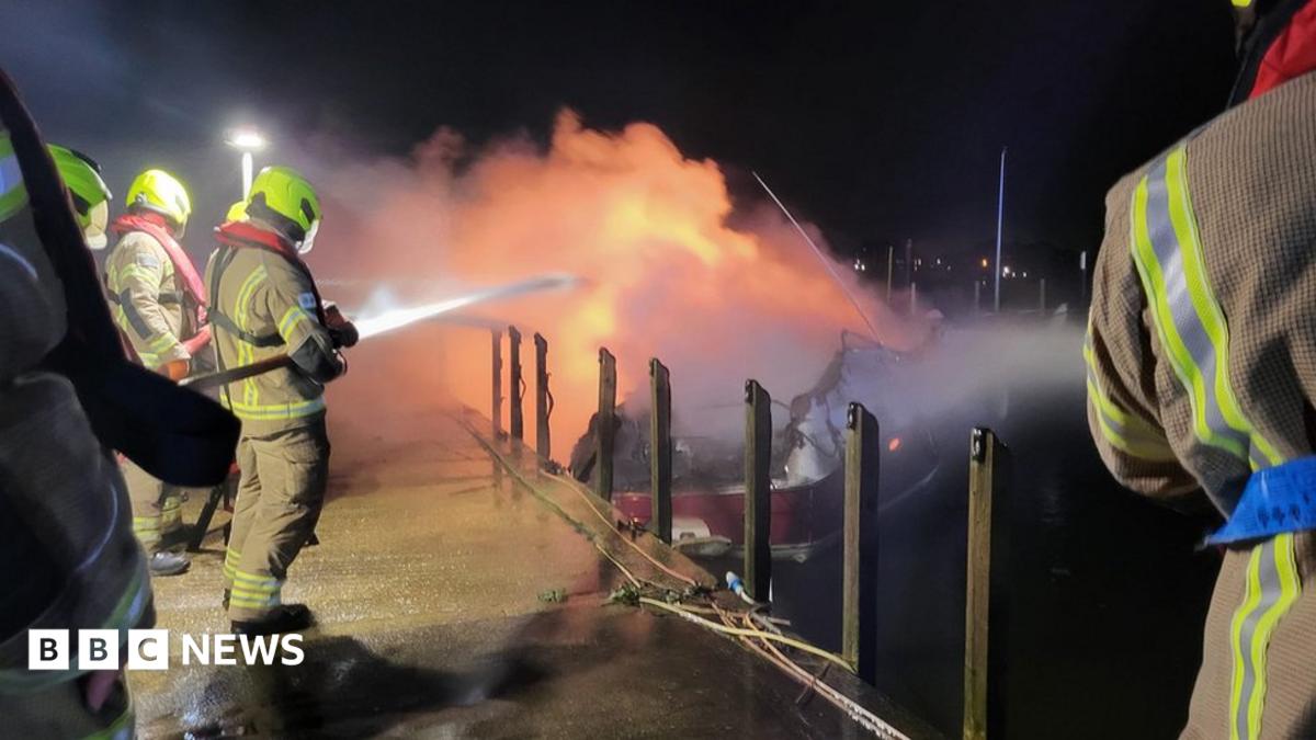 Crews tackle fire involving three boats in Oulton Broad - BBC News