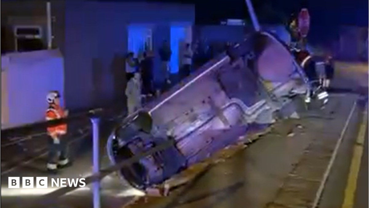 Crash leaves car dangling over Jersey railing - BBC News