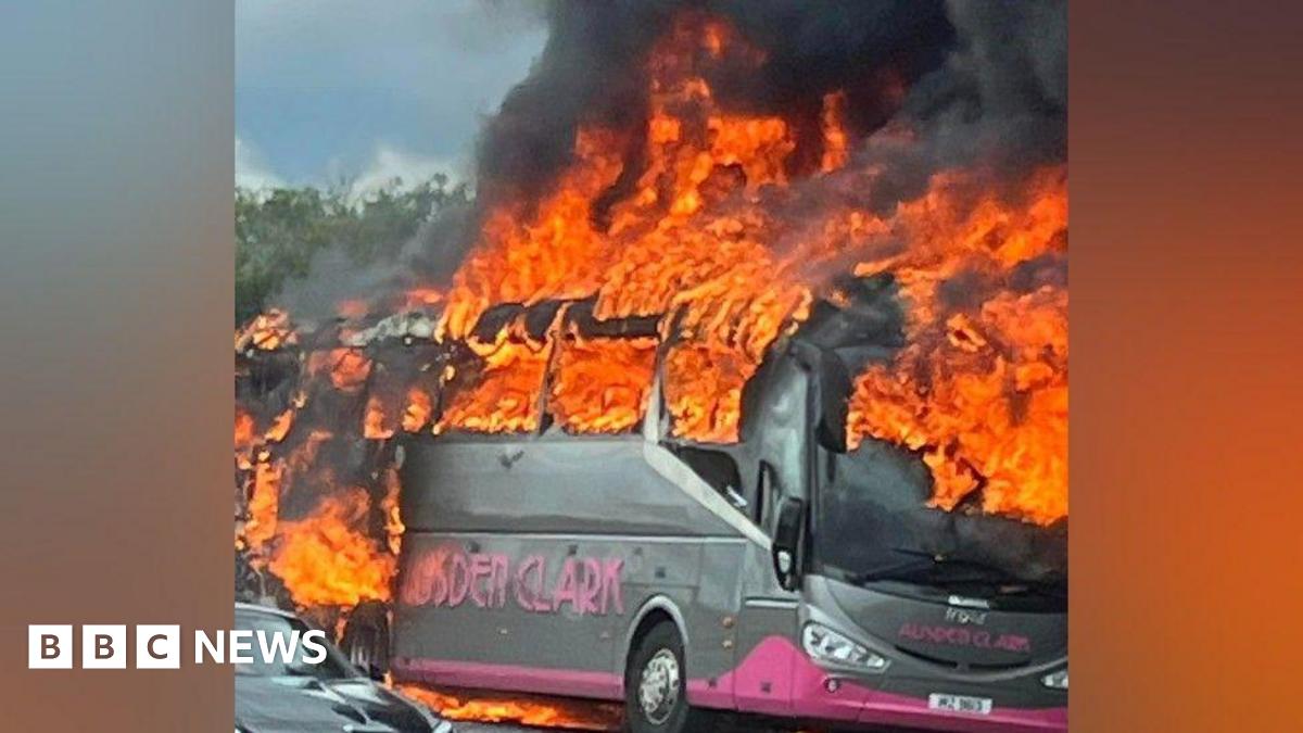 Driver's lucky escape as coach engulfed in flames on major road - BBC News