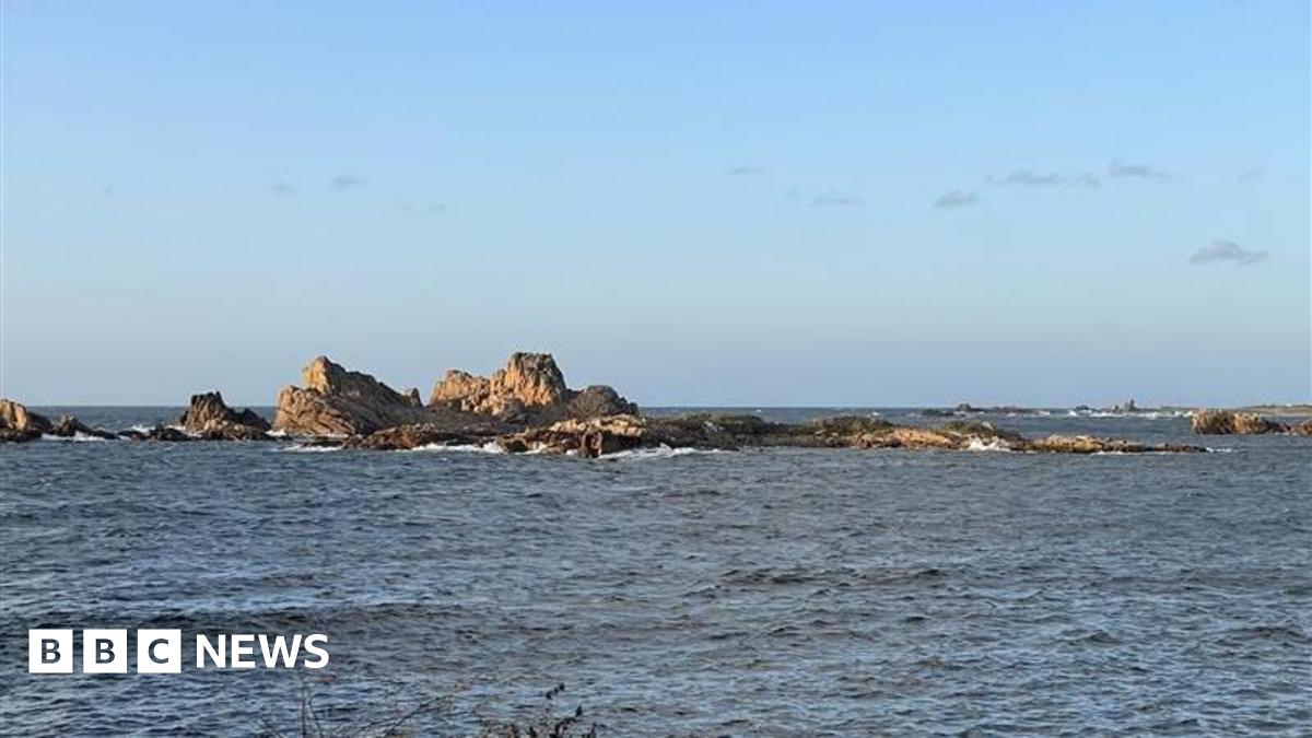 Police wade through water to rescue children stranded on rocks - BBC News