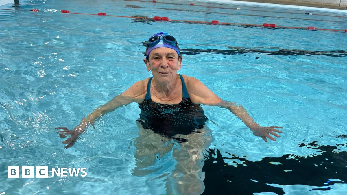 Woman repeats feat of being first to swim at March pool - BBC News