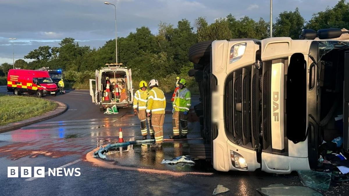 M40: Lorry carrying water tips over blocking slip road - BBC News