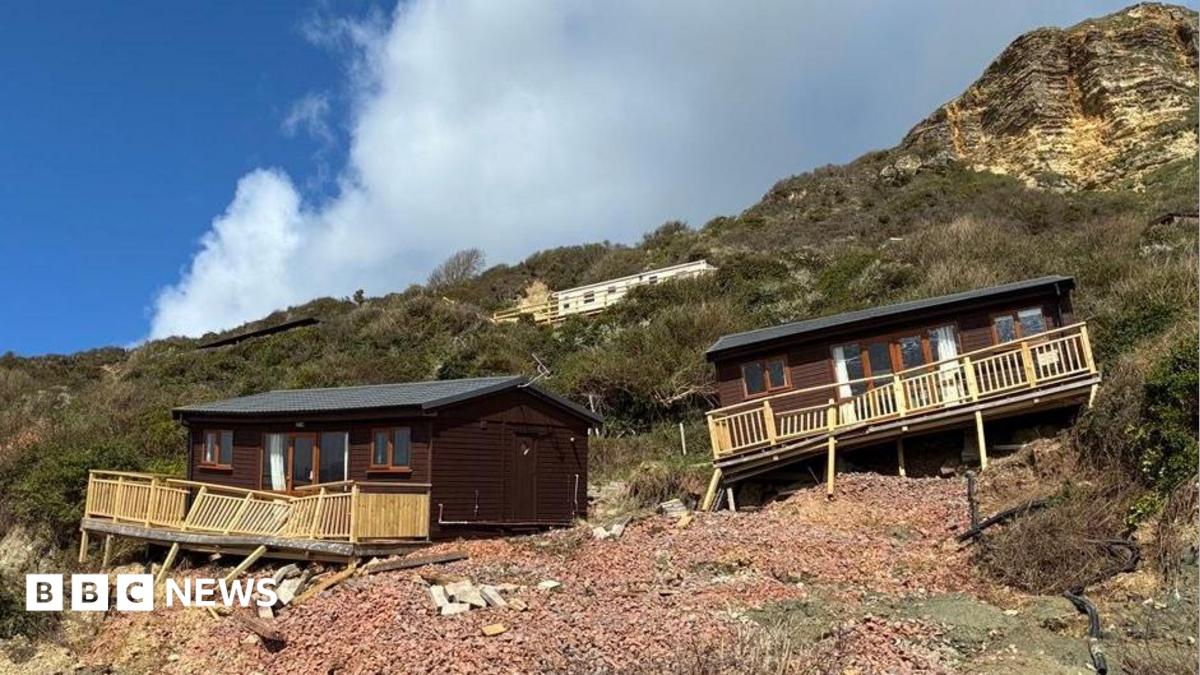 Devon beach chalets teetering after landslide - BBC News