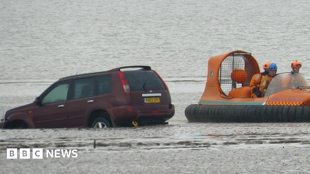 Drivers rescued after three cars stranded in beach mud - BBC News
