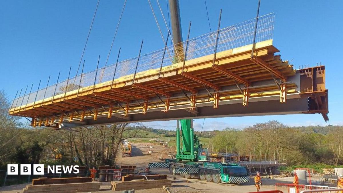 Dawlish link road project bridge craned into place - BBC News