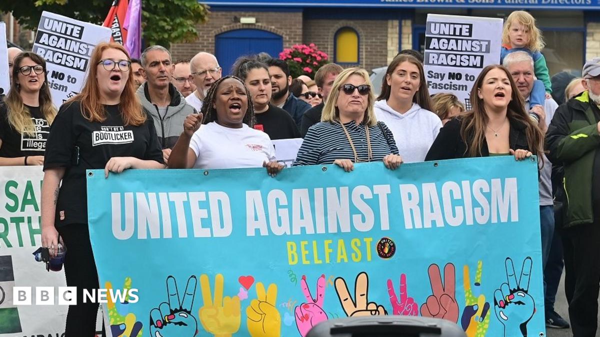 Dunmurry: Anti-racism rally after Nazi flags flown near mosque - BBC News