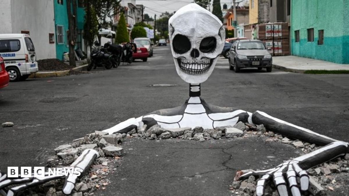 Day of the Dead: Giant skeleton 'crawls out' of Mexico street - BBC News