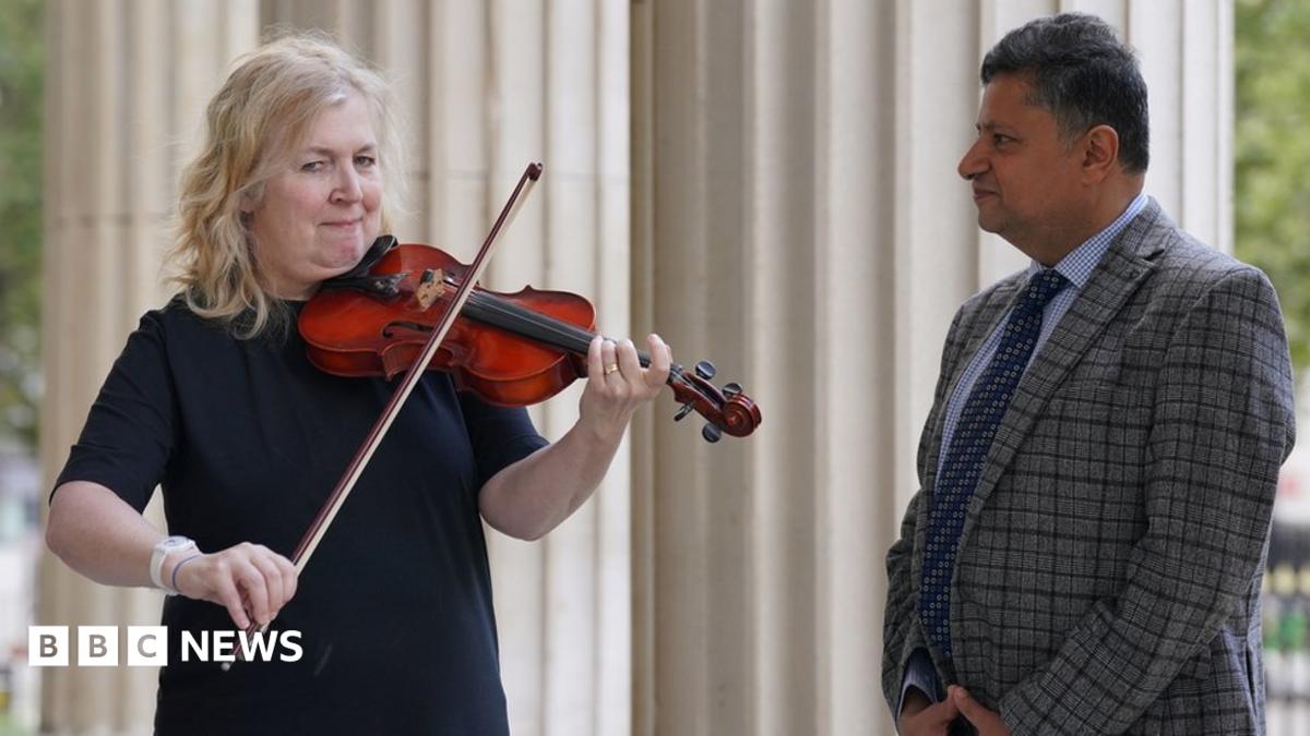 Violinist who played during brain surgery reunites with doctor - BBC News