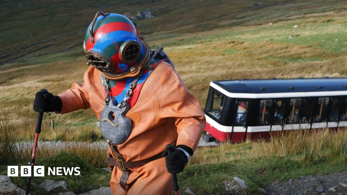 Snowdon: Lloyd Scott starts walk up mountain in diving suit - BBC News