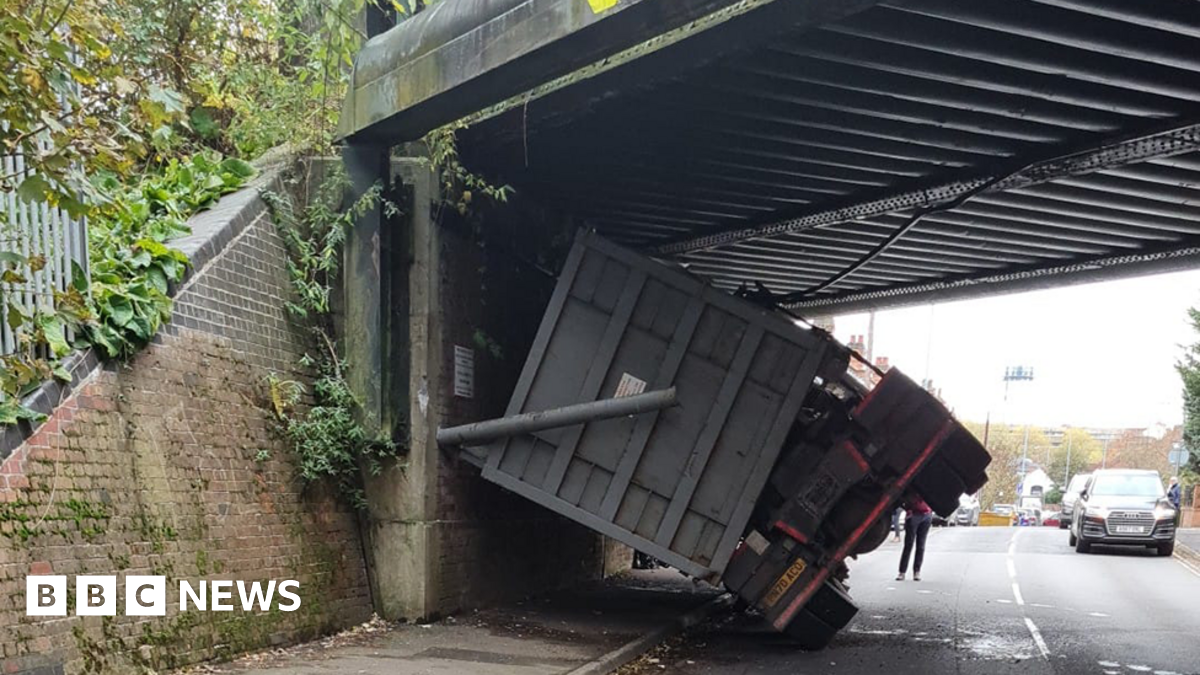 Lorry wedged under Warwick railway bridge after crash - BBC News