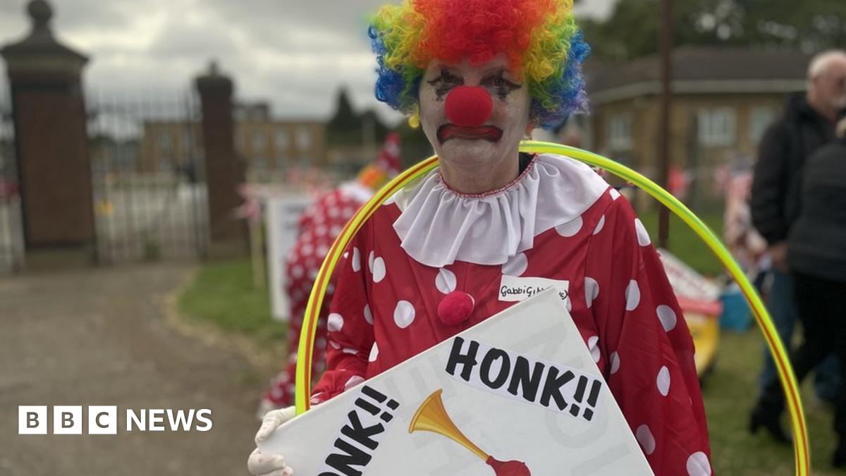 RAF Scampton asylum plan opponents stage 'clown' rally at site - BBC News