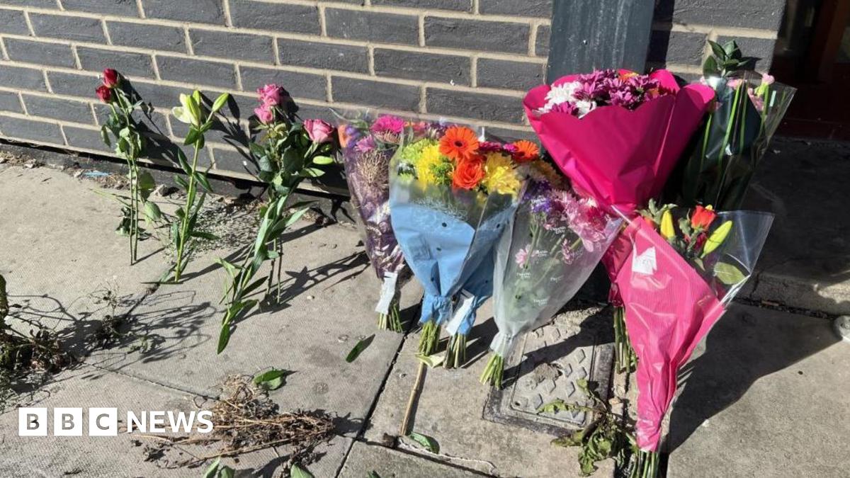 Tributes left as teen held over Luton tower block deaths - BBC News
