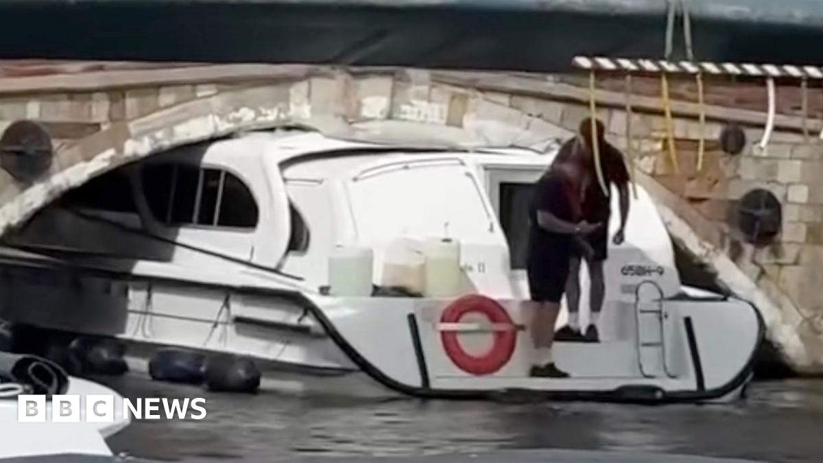 Boat freed after getting stuck under Wroxham bridge - BBC News