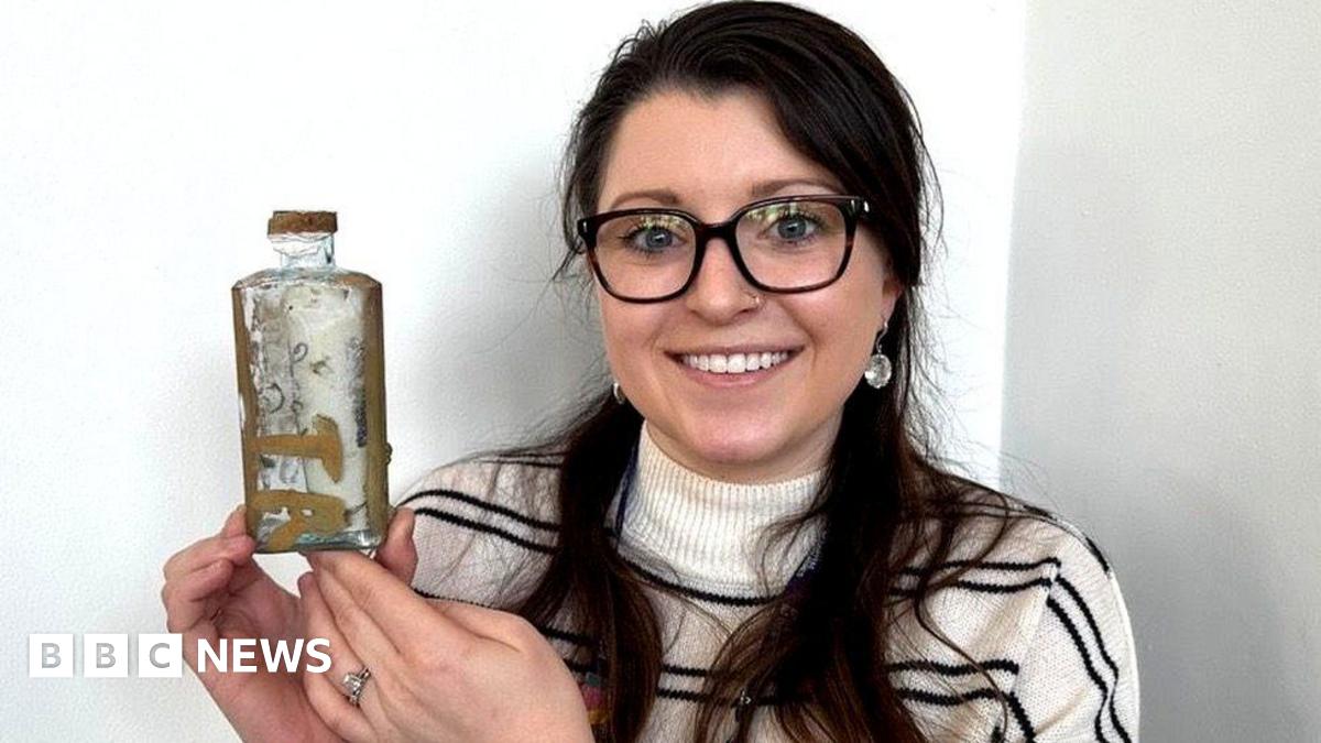 119-year-old bottle found behind crown above theatre stage - BBC News