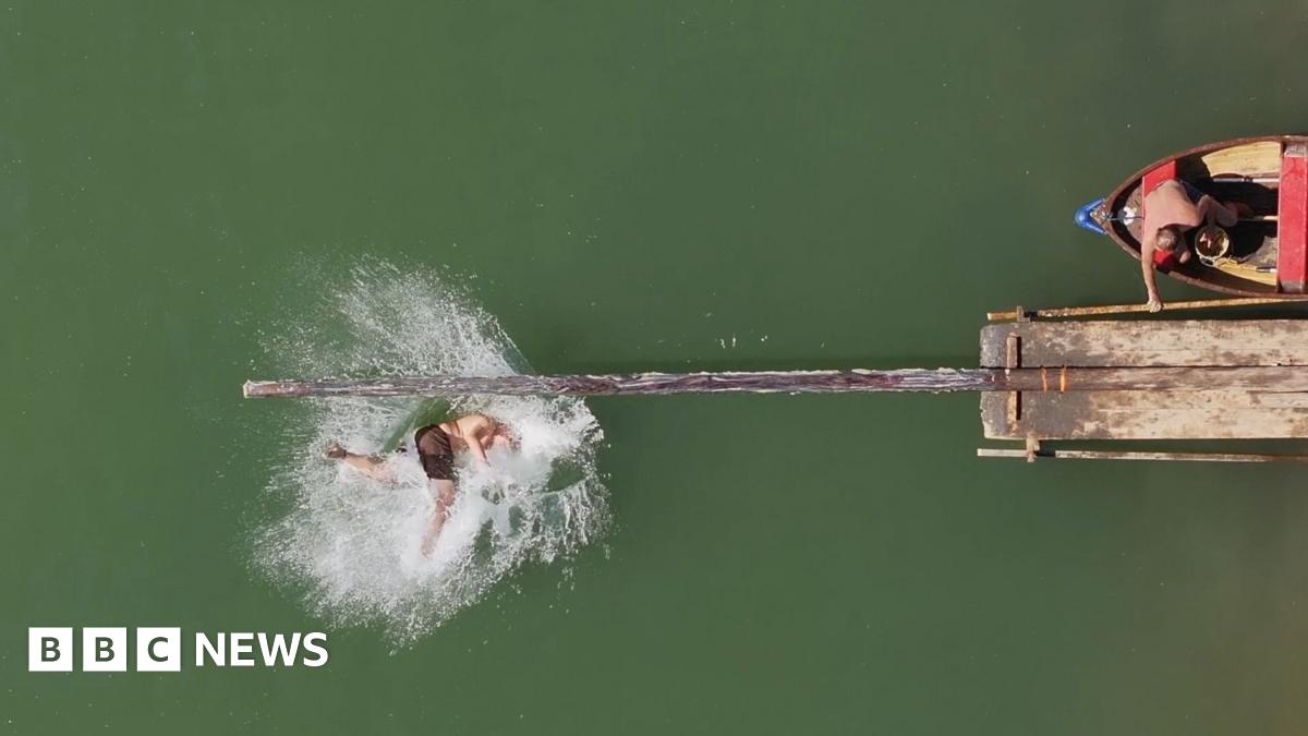 Competitors take on the greasy pole challenge in Blakeney - BBC News