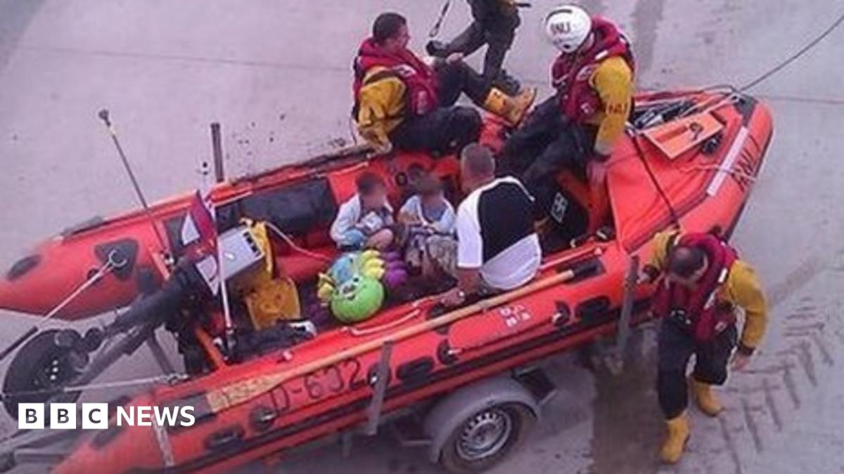 Three in mud rescue near Rhyl harbour wall - BBC News