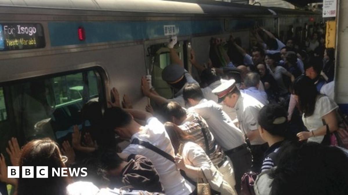 Japan commuters free woman trapped under train - BBC News