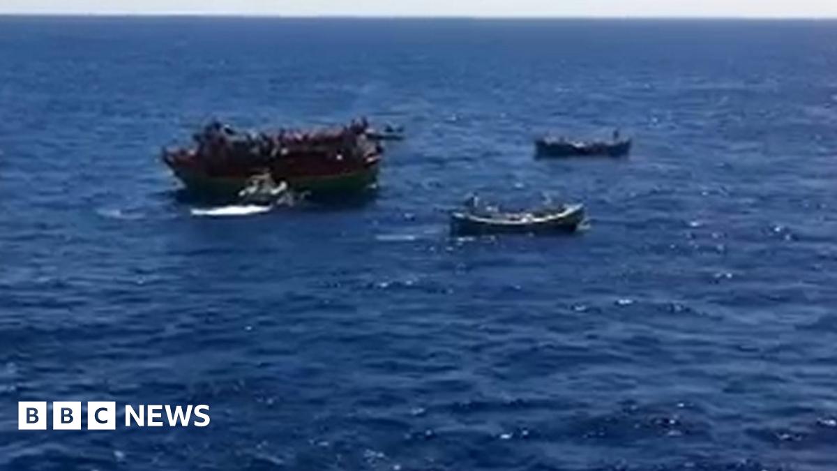 Migrants pulled from overloaded boat by Italian navy - BBC News