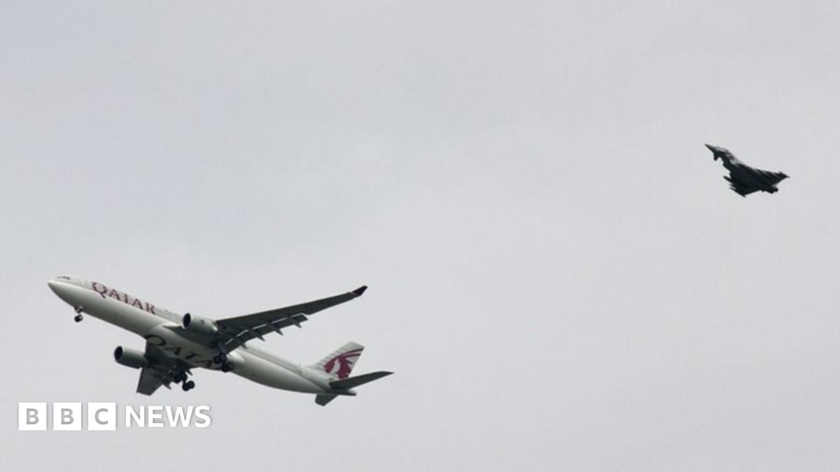 Military jet escorts Qatar Airways plane to Manchester Airport - BBC News