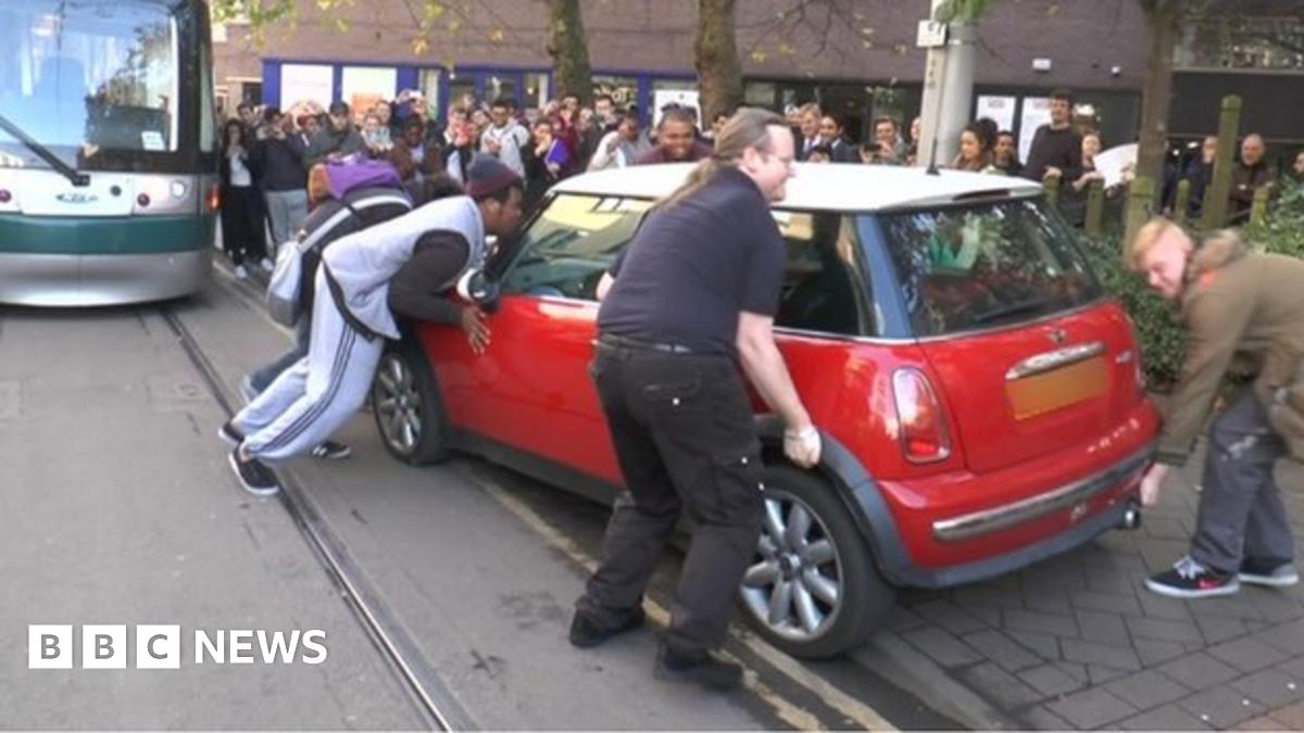 Bystanders lift car to end 'stand-off' with tram - BBC News