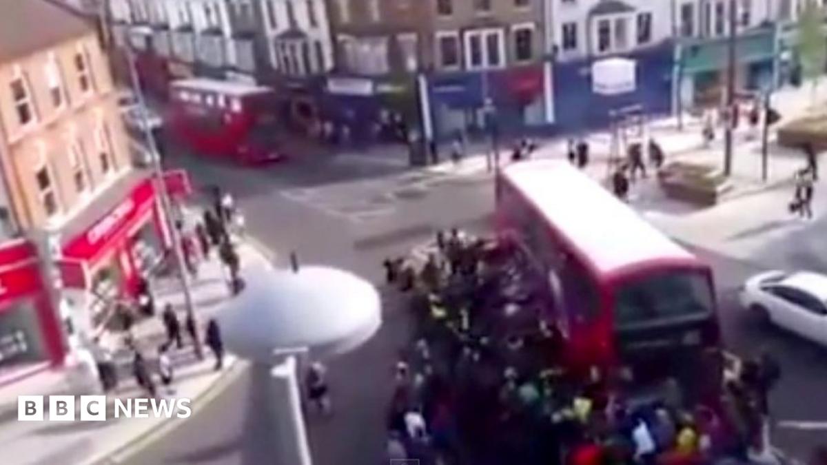 Amazing video as crowd 'lifts' bus from trapped cyclist - BBC News