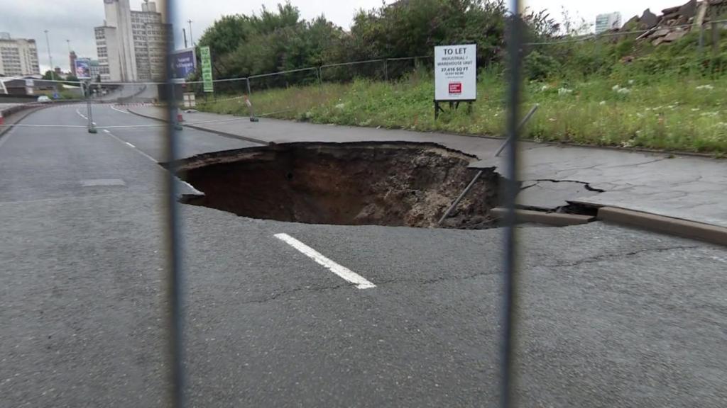 Heavy rain causes a sinkhole in Manchester - BBC Newsround