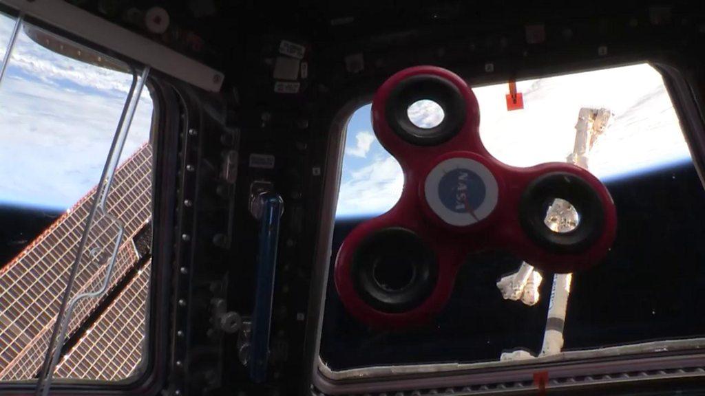 Astronauts playing with a fidget spinner in space - BBC Newsround