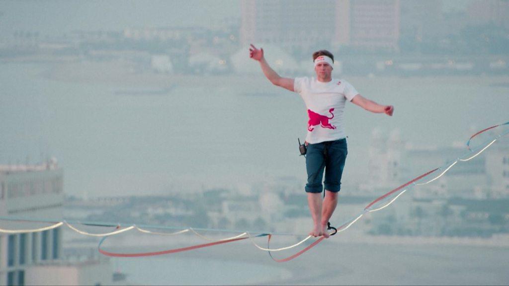 Qatar: Man completes longest single-building slackline - BBC Newsround