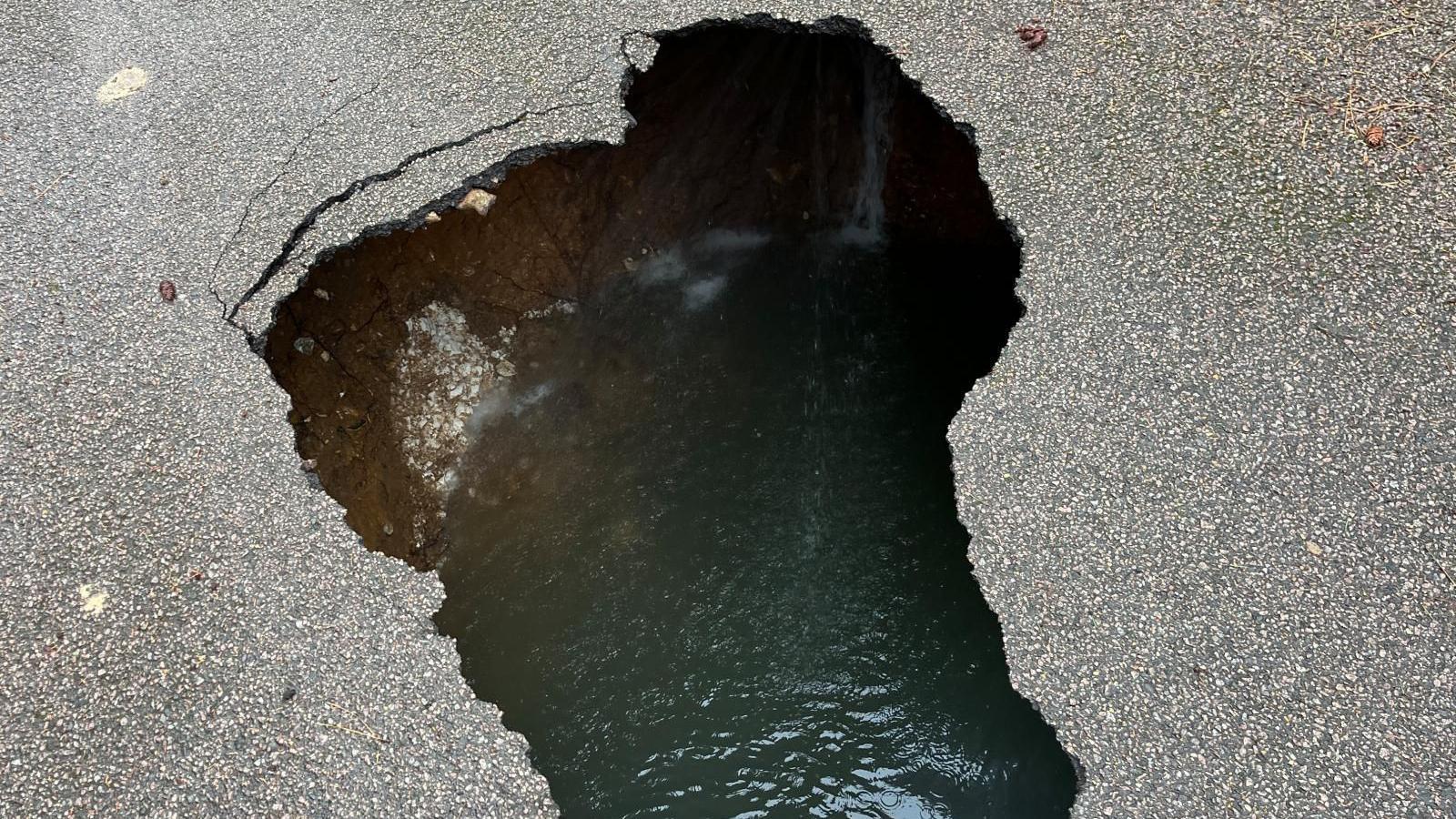 Water-filled sinkhole appears on residential road in Harpenden - BBC News