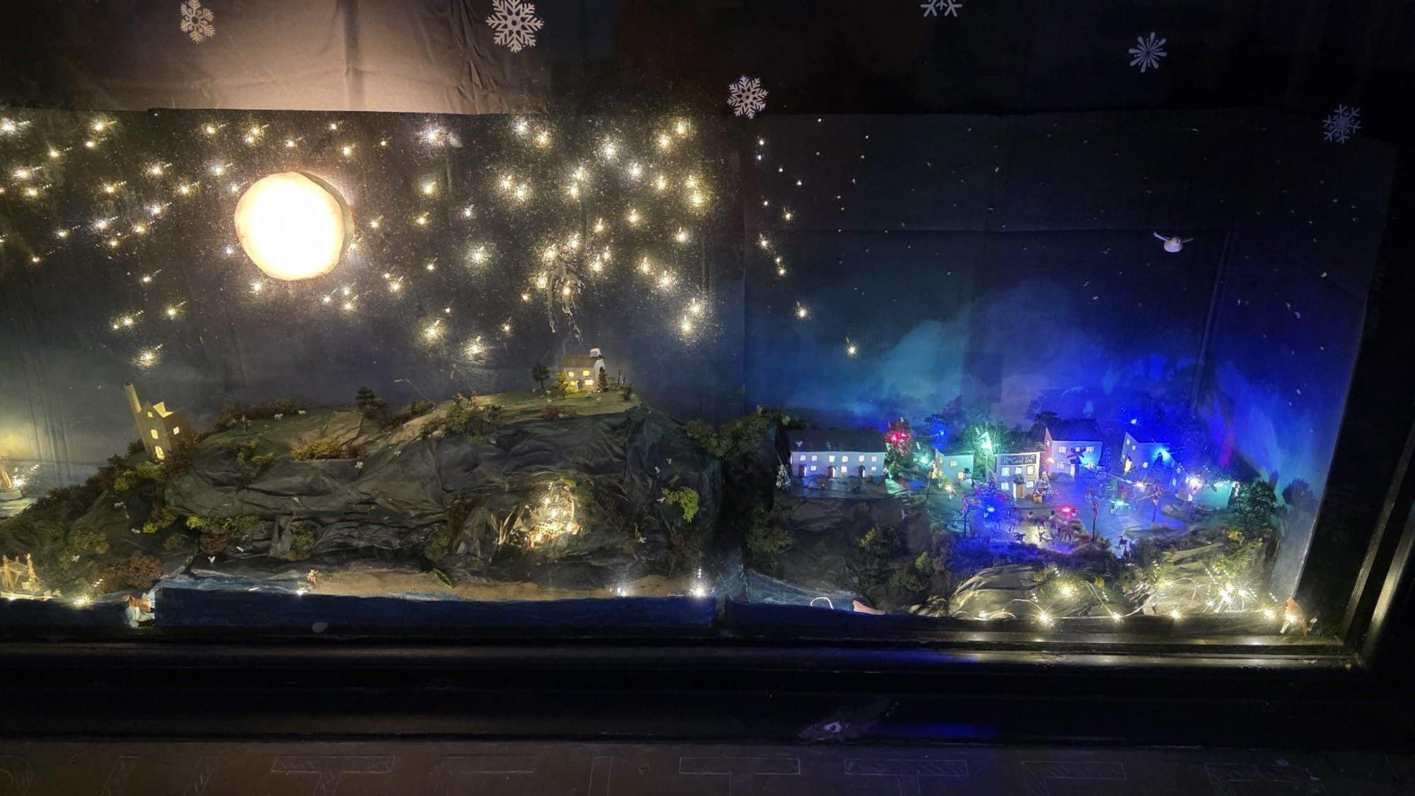 Calstock Advent windows light village up for Christmas - BBC News