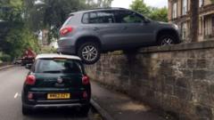 Car comes to rest on roof of Fiat 500 in Glasgow - BBC News