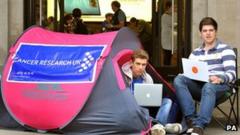 Cancer fundraisers camp for new Apple iPhone - BBC News