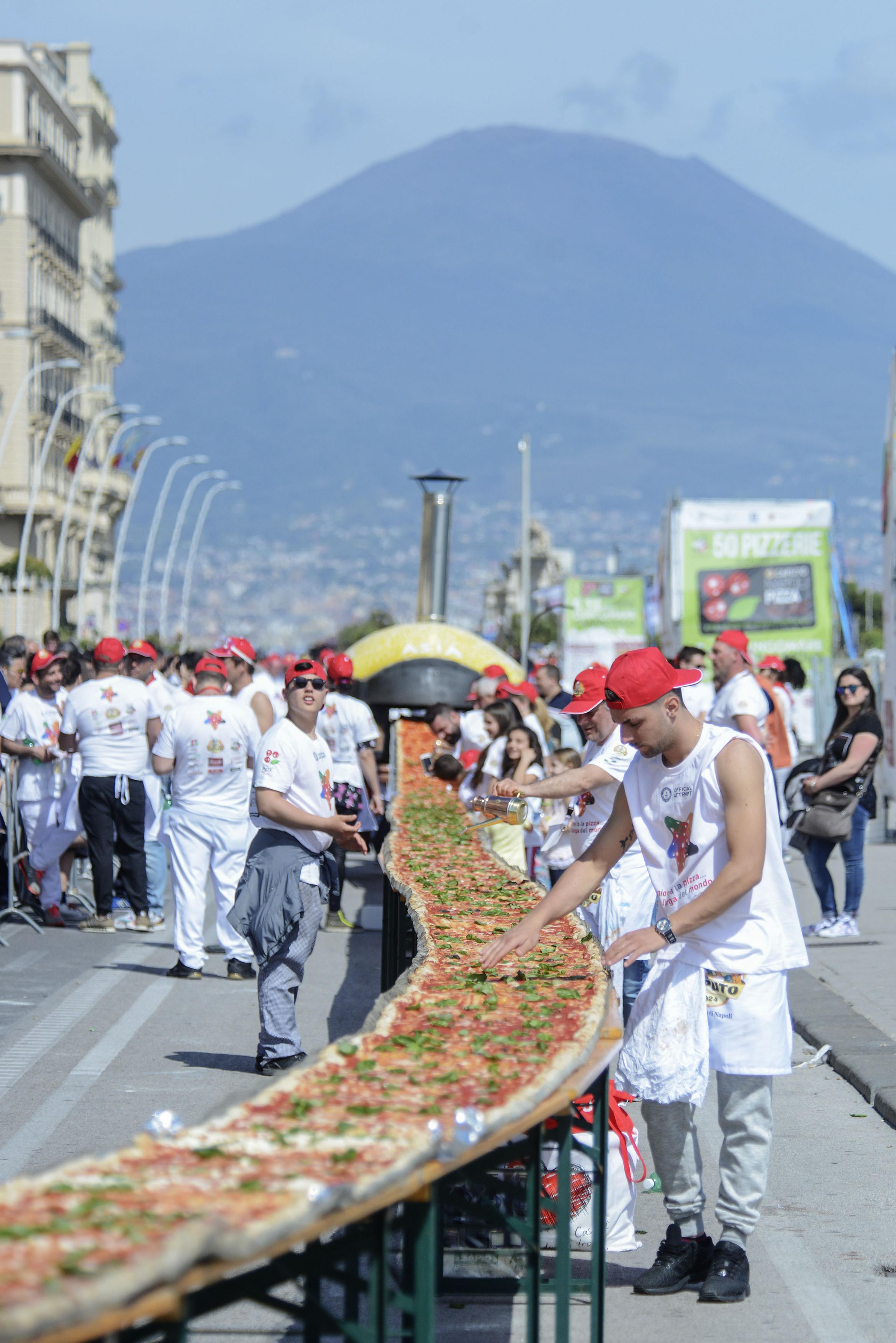 Pictures: Guinness World record set for longest pizza ever - BBC Newsround