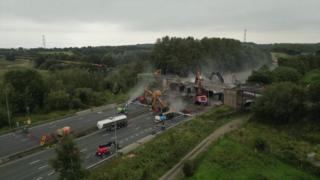 Workers start to demolish M62 Castleton rail bridge - BBC News