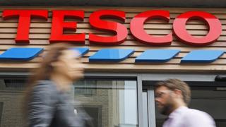 Tesco sees profits halve to £1bn as costs rise - BBC News