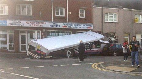 Two passengers hurt as bus hits shop in Swansea street - BBC News