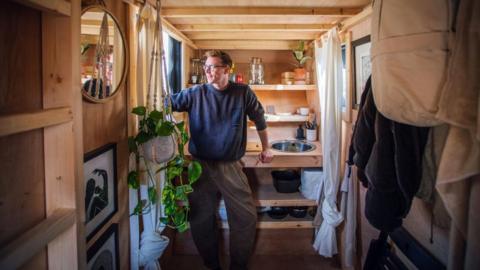 Cost of living: Artist living in converted skip in Bermondsey - BBC News