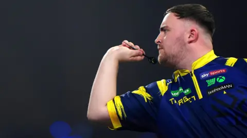 Luke Littler throws a dart