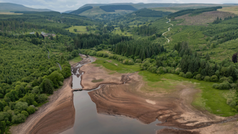 Sunken bridge reappears in dry spell at Llwyn-Onn reservoir - BBC News