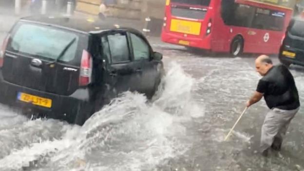 Flooding in London: Heavy rain causes travel disruption - BBC News