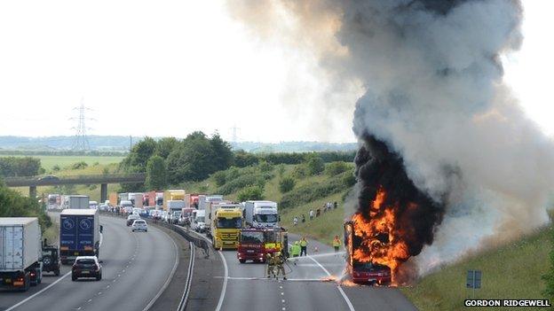 Double decker bus on M11 gutted by fire in Essex - BBC News
