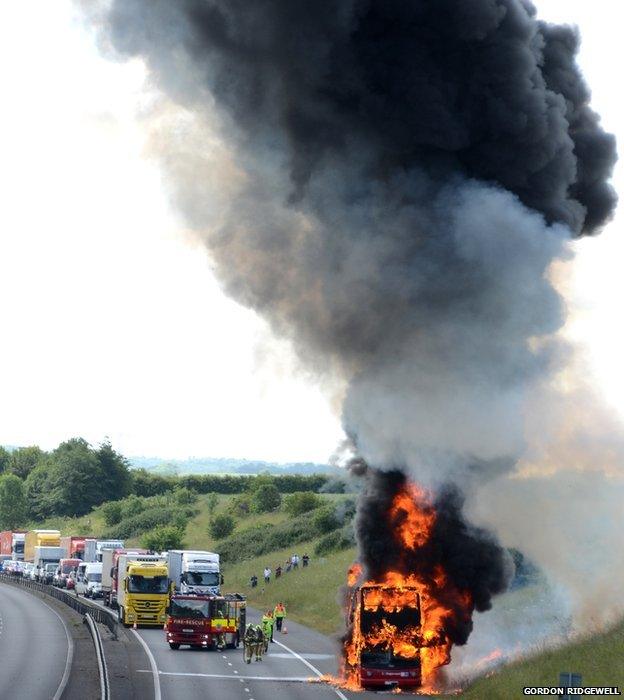 Double decker bus on M11 gutted by fire in Essex - BBC News