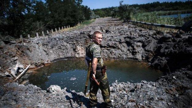 A pro-Russian gunman next to a bomb crater near Donetsk (14 August 2014)