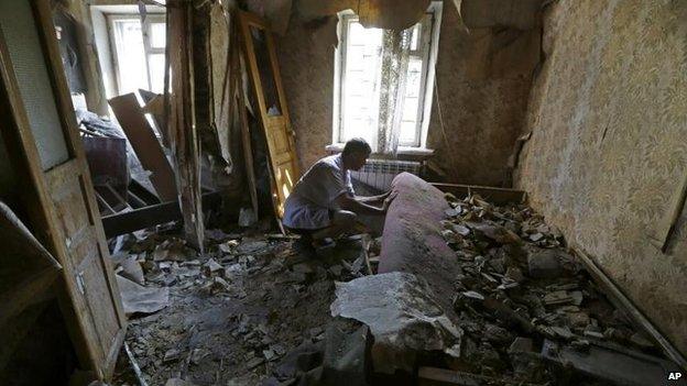 A resident of Donetsk inspects shell damage (14 August 2014)