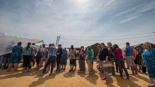 Ukrainians queue for food at a refugee camp in Rostov region in Russia (August 2014)