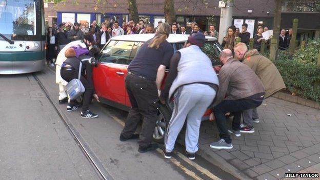 Bystanders lift car to end 'stand-off' with tram - BBC News