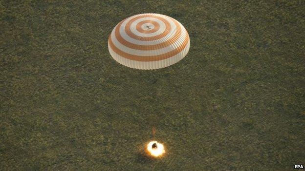 Three ISS astronauts return to Earth after month-long delay - BBC News