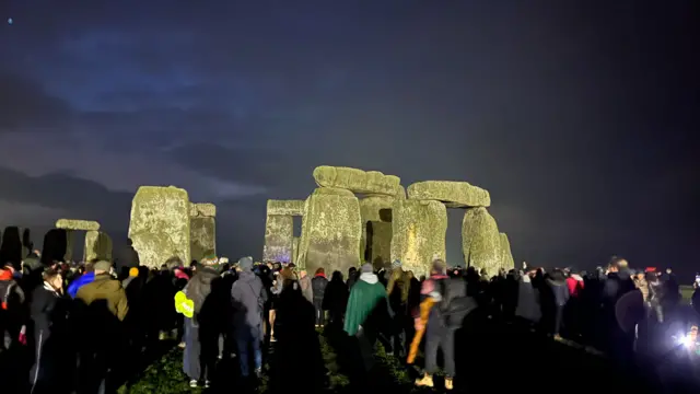 Thousands welcome winter solstice as Sun rises over Stonehenge - BBC News