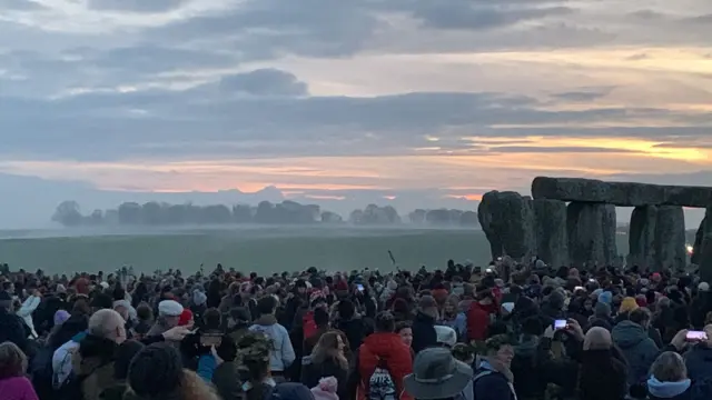 Thousands welcome winter solstice as Sun rises over Stonehenge - BBC News
